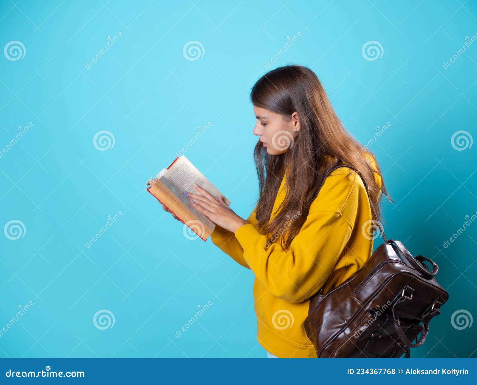 A Student with a Book in Her Hands, Reading a Textbook and Preparing ...