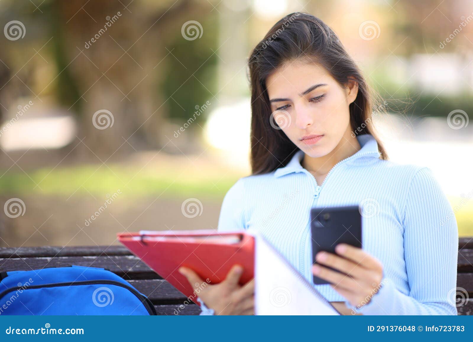 Student Checking Phone Sitting in a Park Stock Photo - Image of girl, concentrated: 291376048