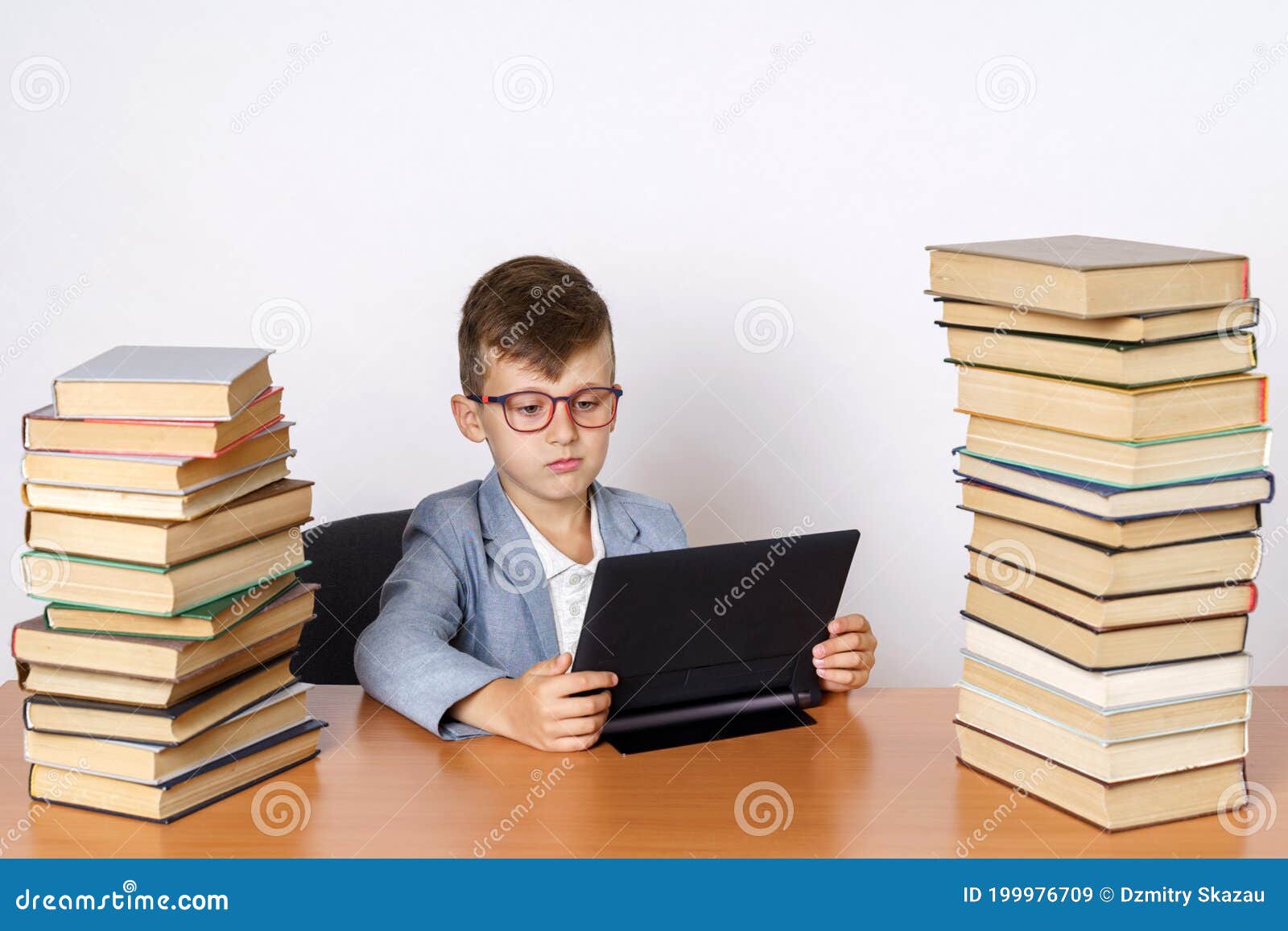 The Student Does Homework Using a Tablet. he Has Books on Both Sides ...