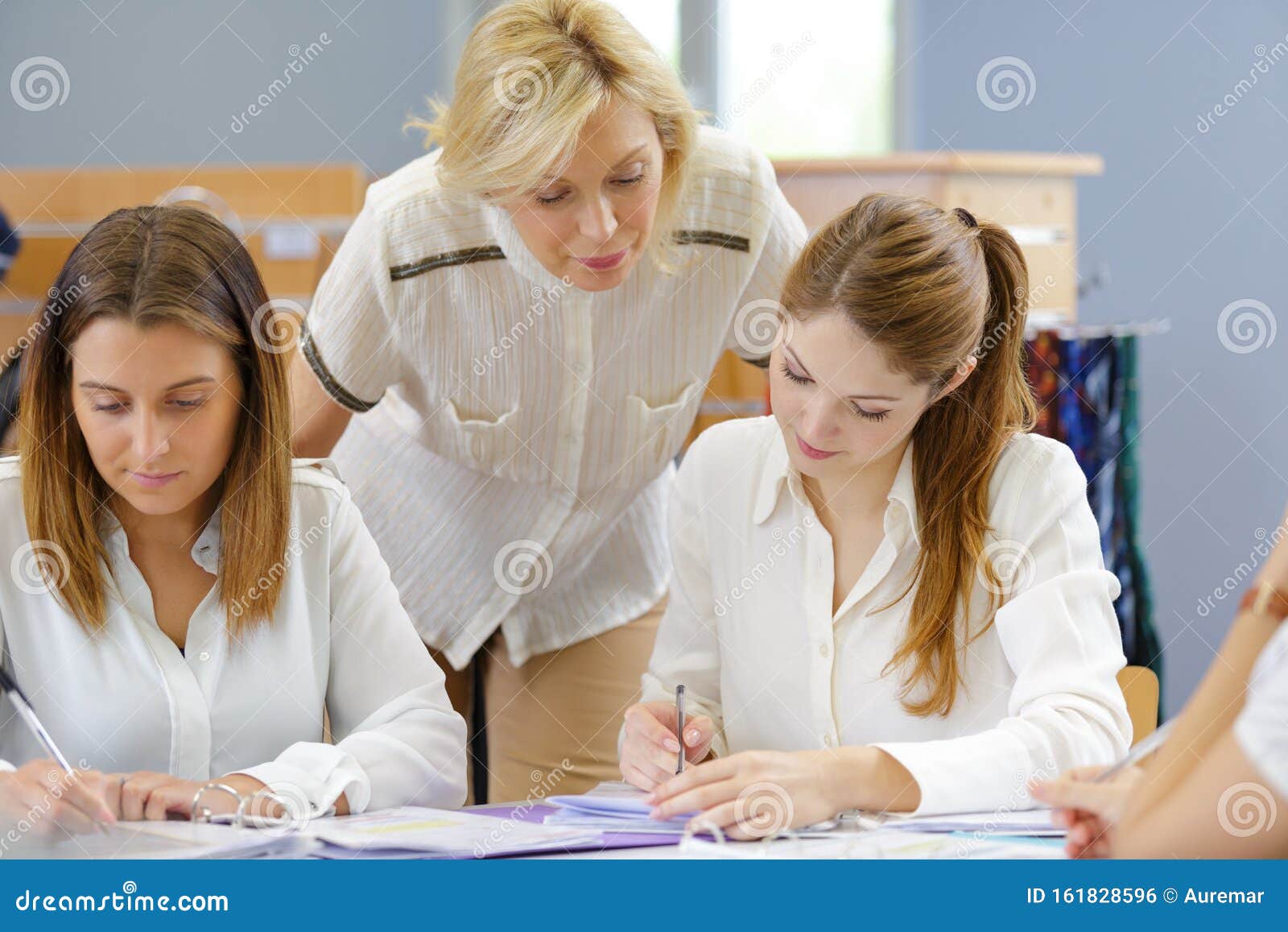 Student Doing Exam Next To Teacher in Classroom Stock Photo - Image of ...