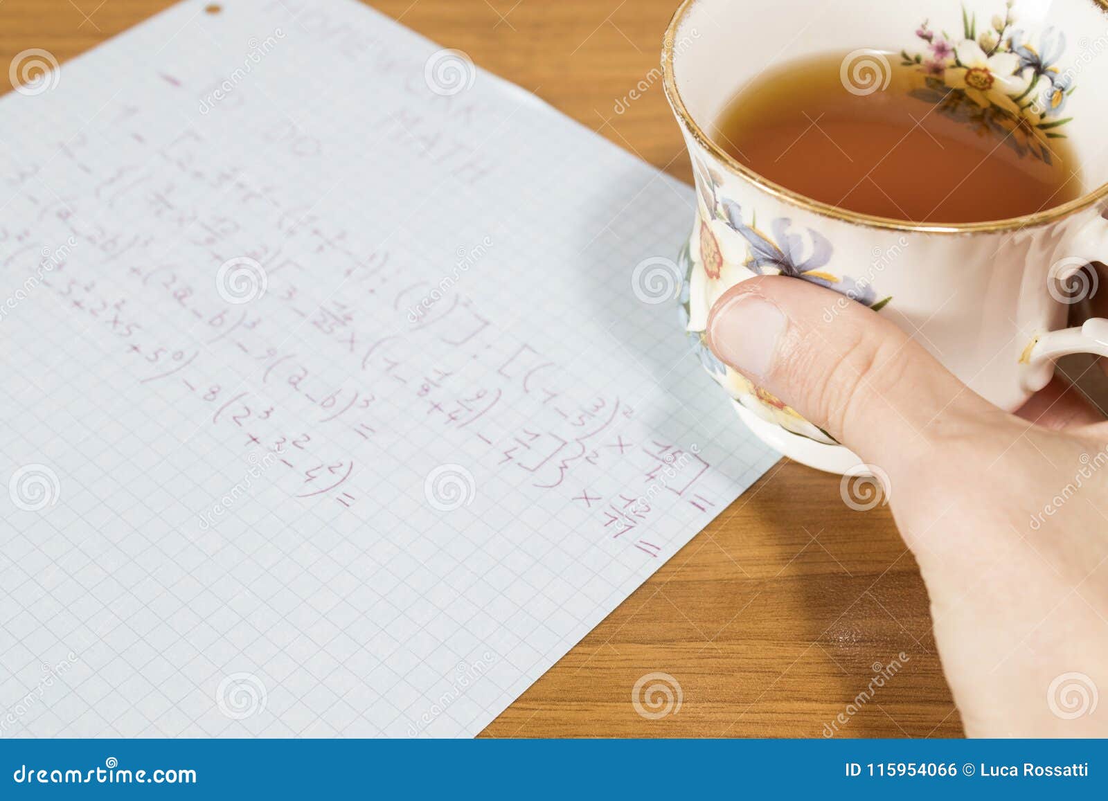 A Student is Doing Math Homework with a Cup of Tea in His Hand Stock ...