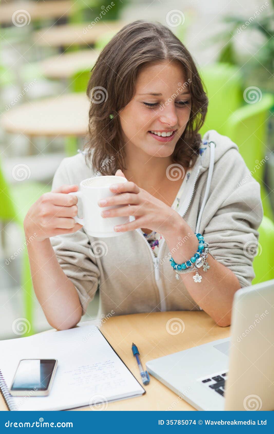 Student Drinking Coffee while Using Laptop at Cafeteria Table Stock ...
