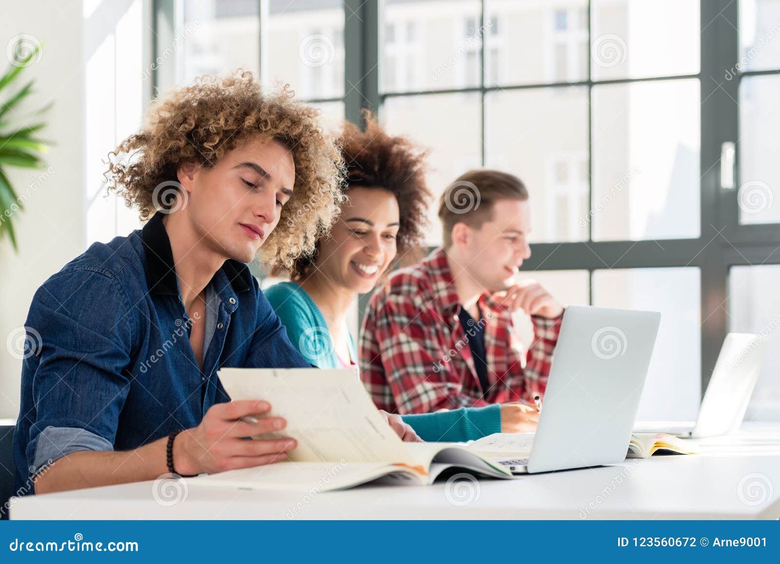 Student in Front of a Book while Sitting Down at Desk Stock Photo ...