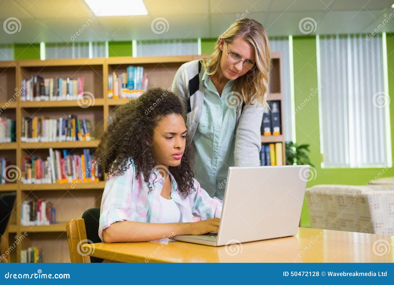Student Getting Help from Tutor in Library Stock Photo - Image of ...