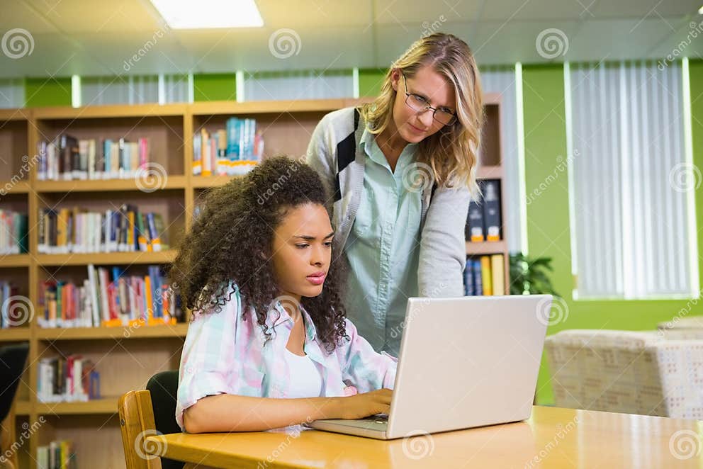 Student Getting Help from Tutor in Library Stock Photo - Image of ...
