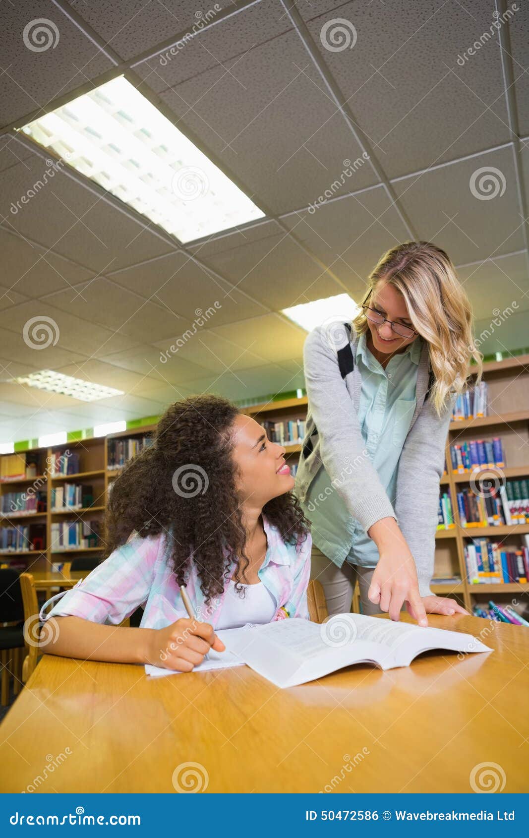 Student Getting Help from Tutor in Library Stock Photo - Image of ...