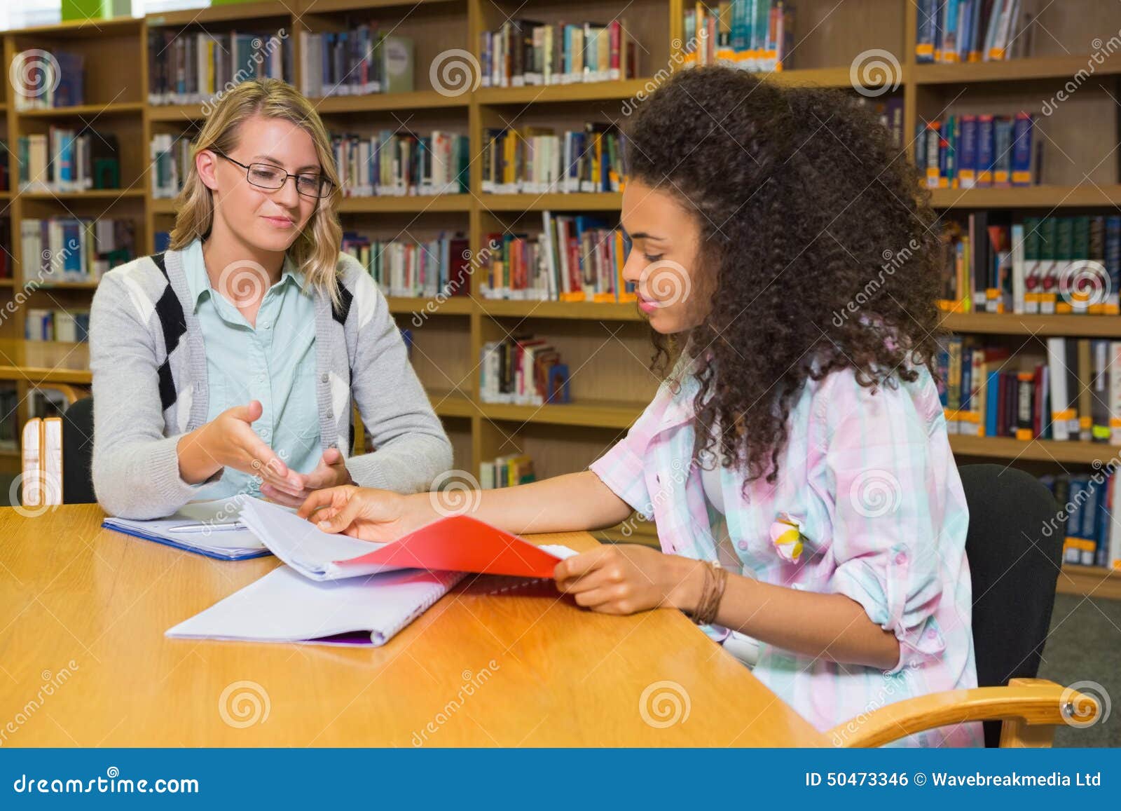 Student Getting Help from Tutor in Library Stock Photo - Image of desk ...