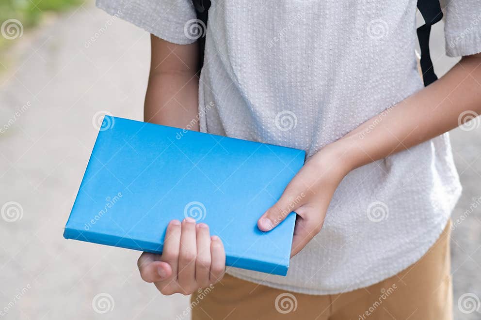A Student Going To School, Holding a Textbook Stock Photo - Image of ...