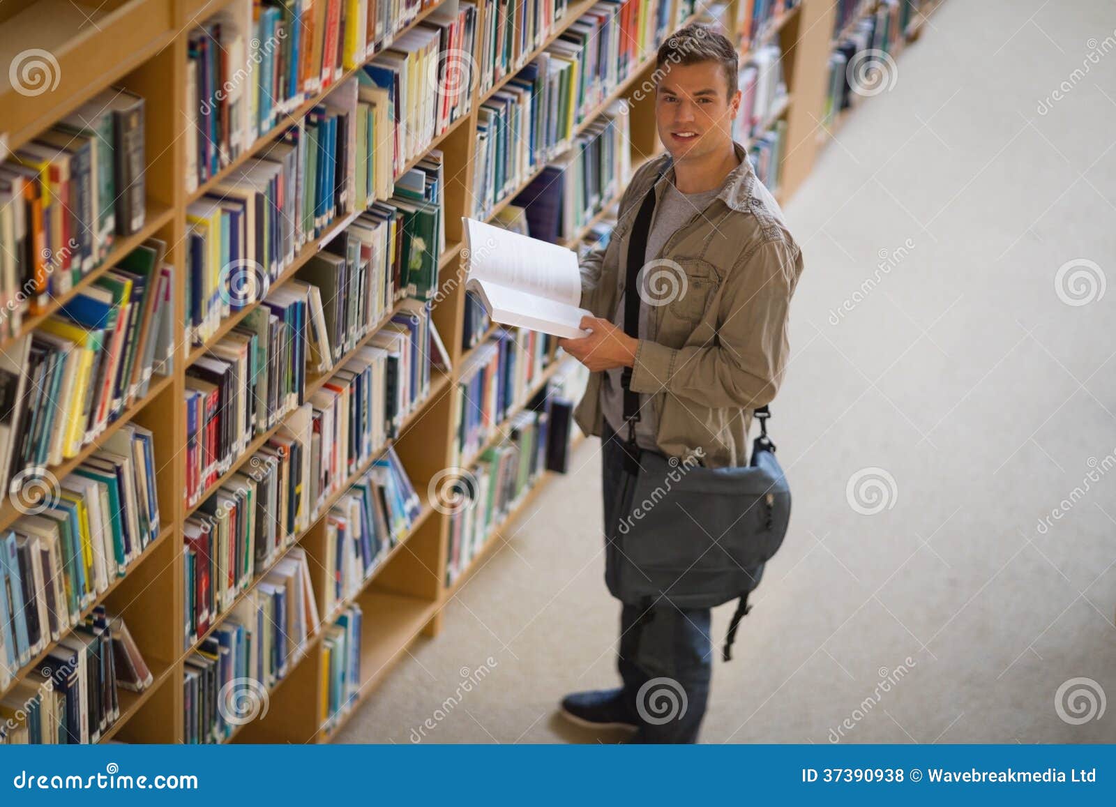 Student Holding a Book from Shelf in Library Smiling at Camera Stock ...