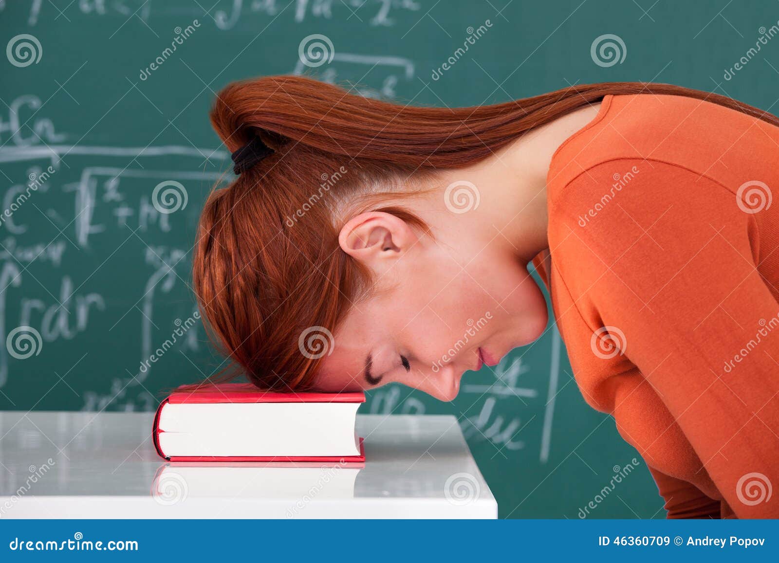 Student Leaning Head on Book in Classroom Stock Image - Image of bored ...
