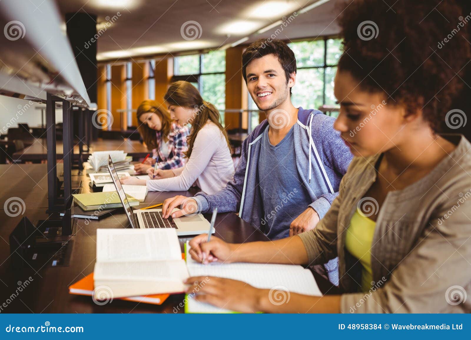 Student Looking at Camera while Studying with Classmates Stock Photo ...