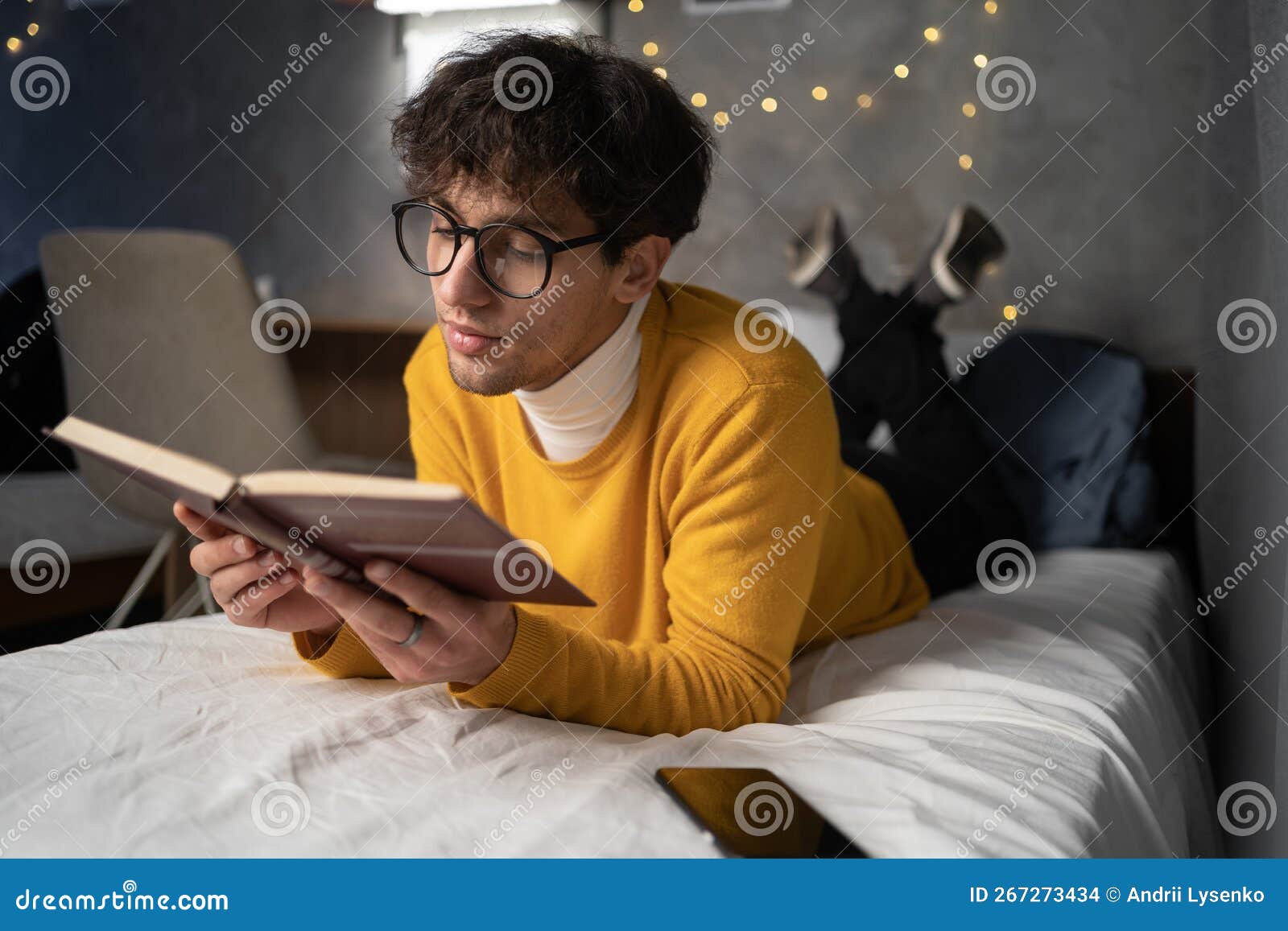 Student Lying on a Bed and Studying with Focus and Concentration in ...