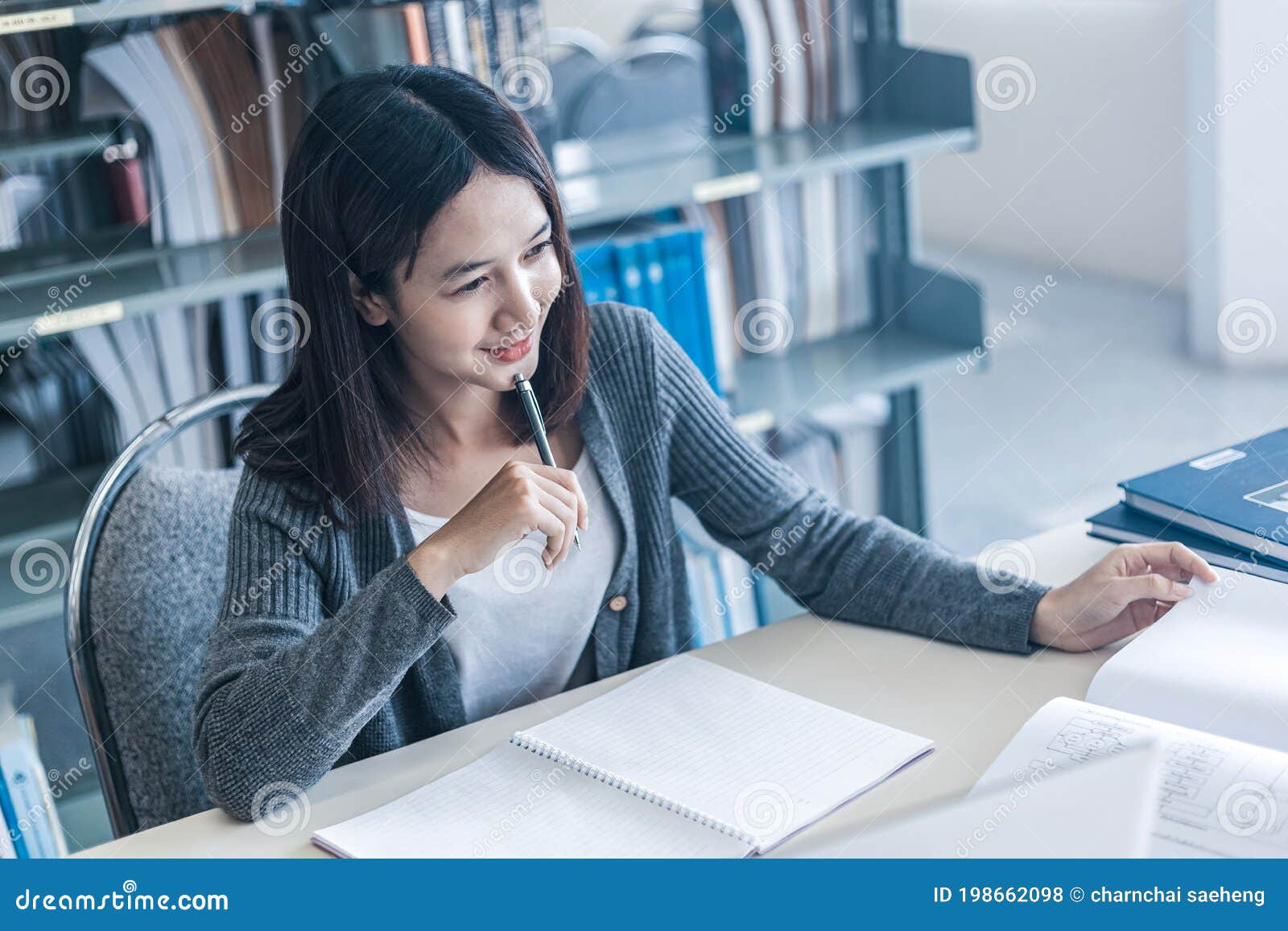 Student Open a Book and Read for Exam in the Library. Education Concept ...
