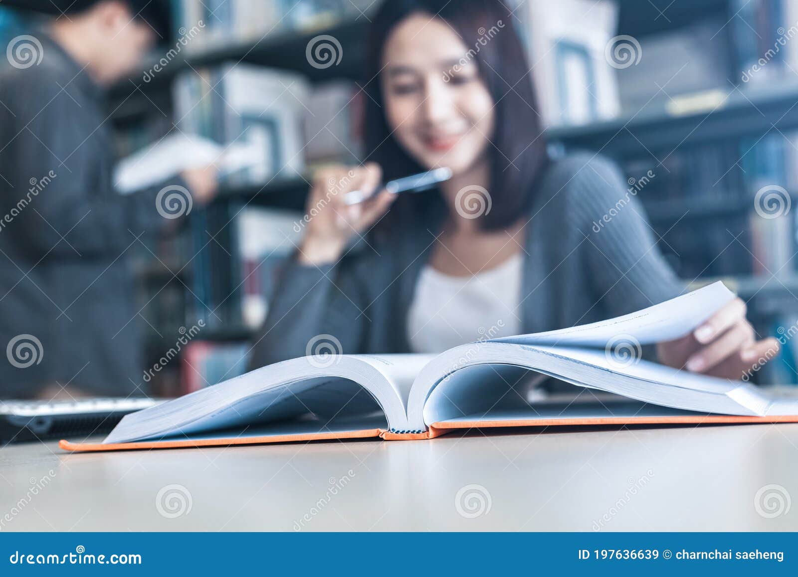 Student Open a Book and Read for Exam in the Library. Education Concept ...