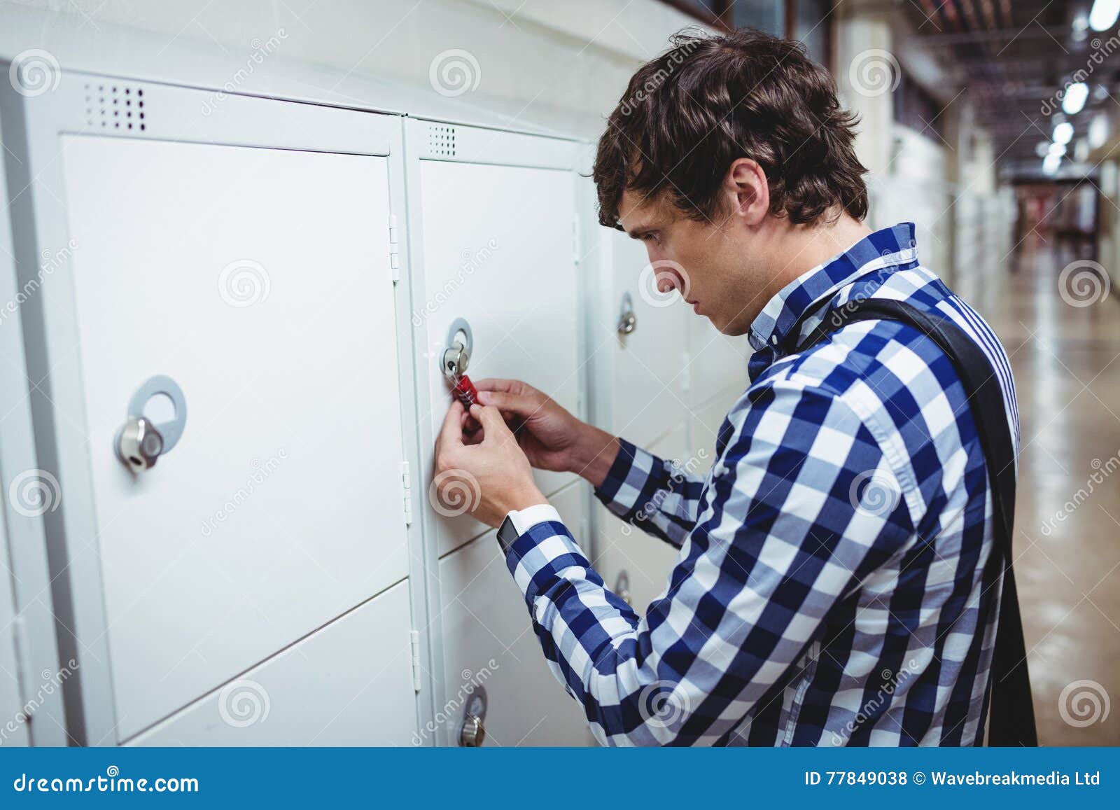 Student opening his locker stock photo. Image of attractive - 77849038