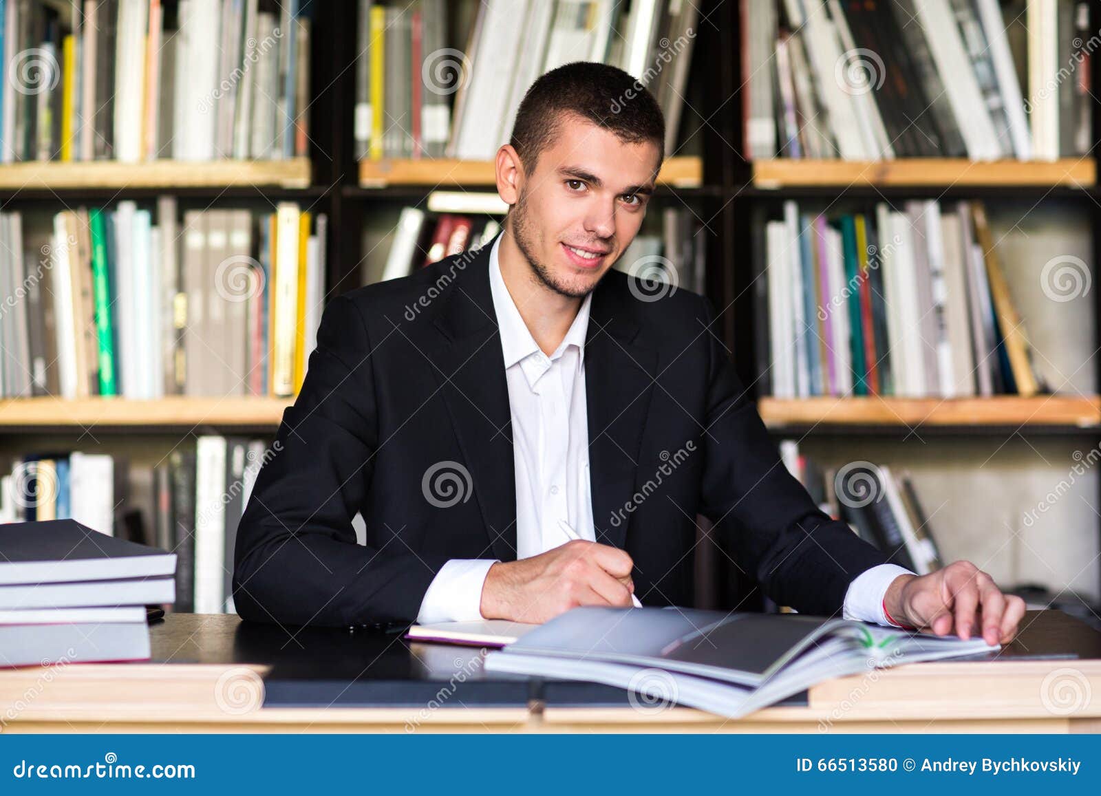 Student Reading a Book in the Library. Guy Reading a Book in a Library ...