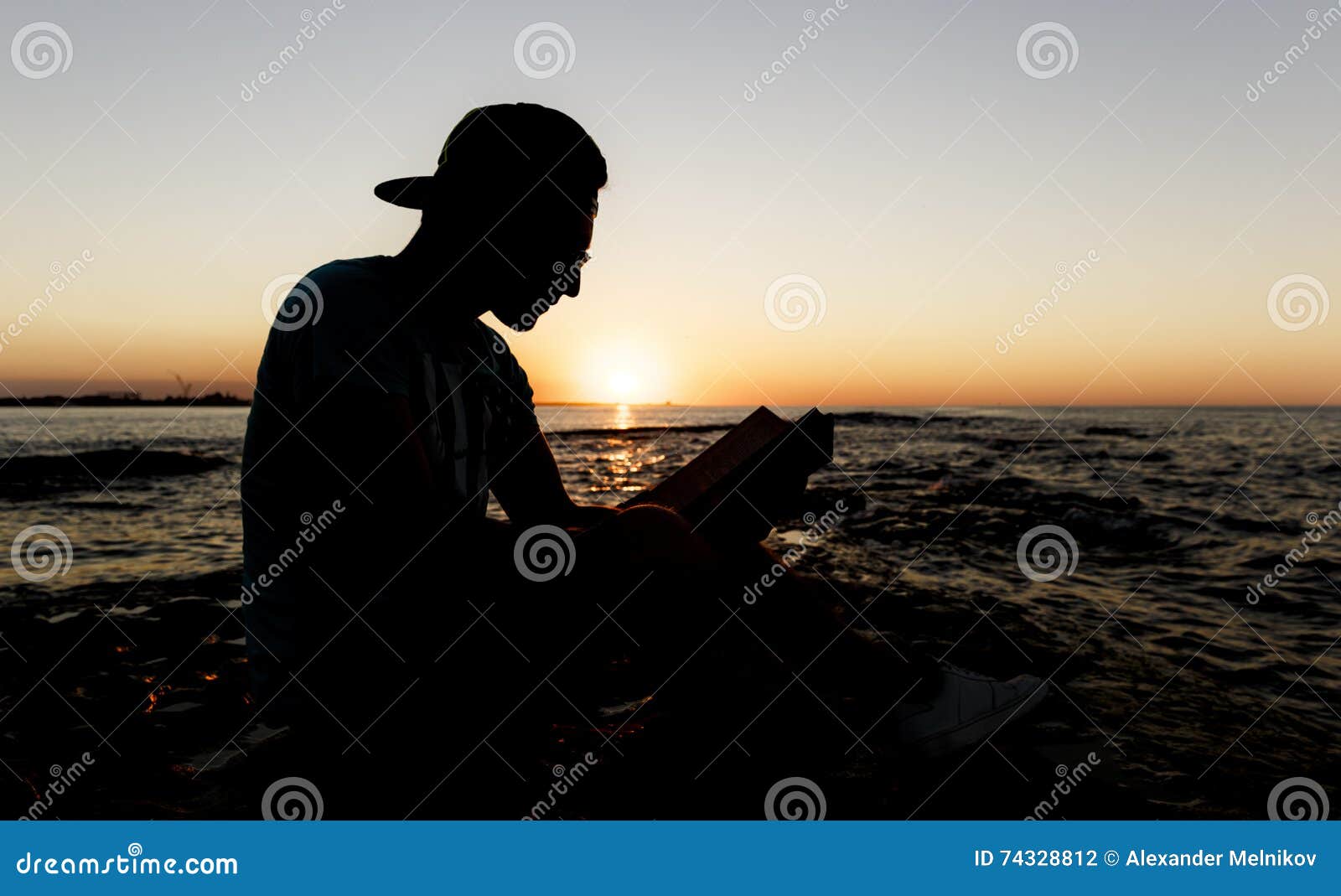 Student Reading a Book by the Sea at Sunset Stock Photo - Image of ...
