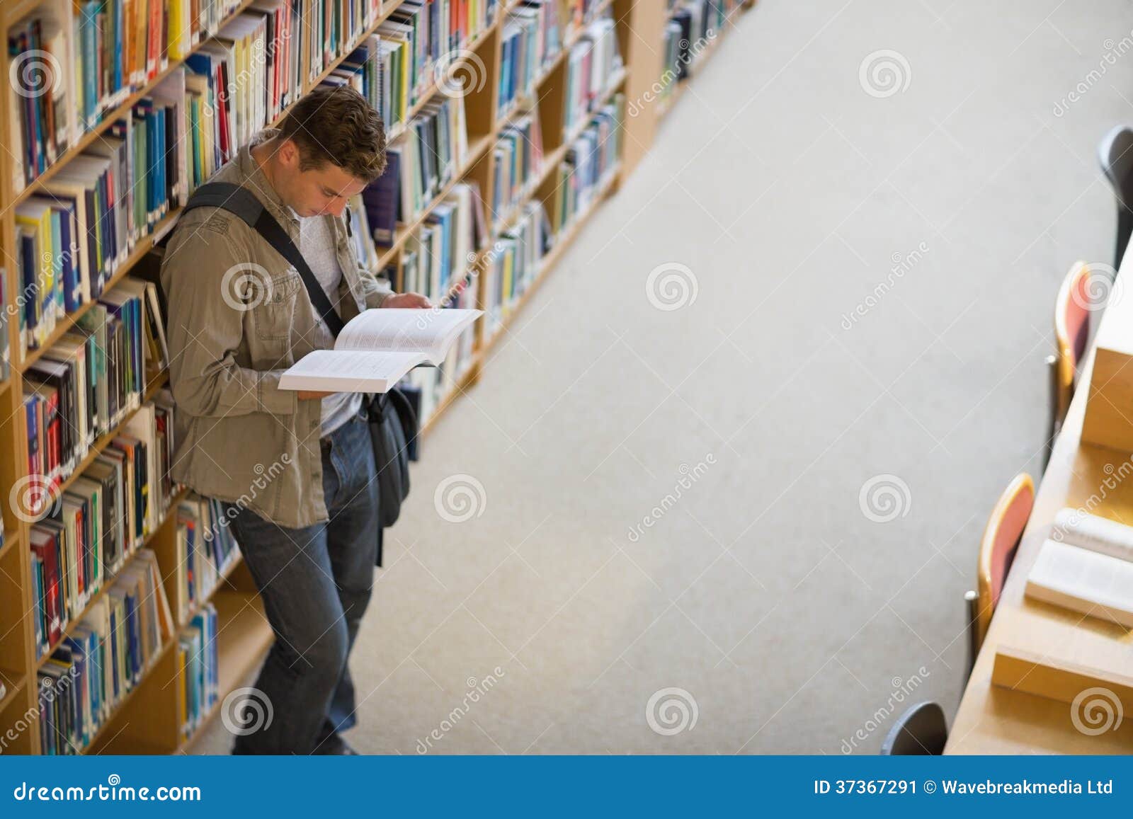 Student Reading a Book from Shelf Standing in Library Stock Image ...