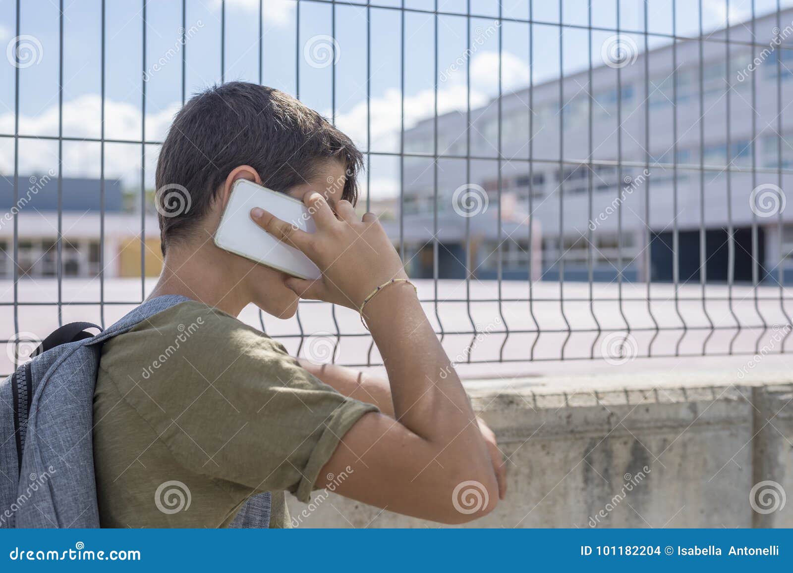 Student Resting Outside a School and Playing with a Mobile Phone Stock ...