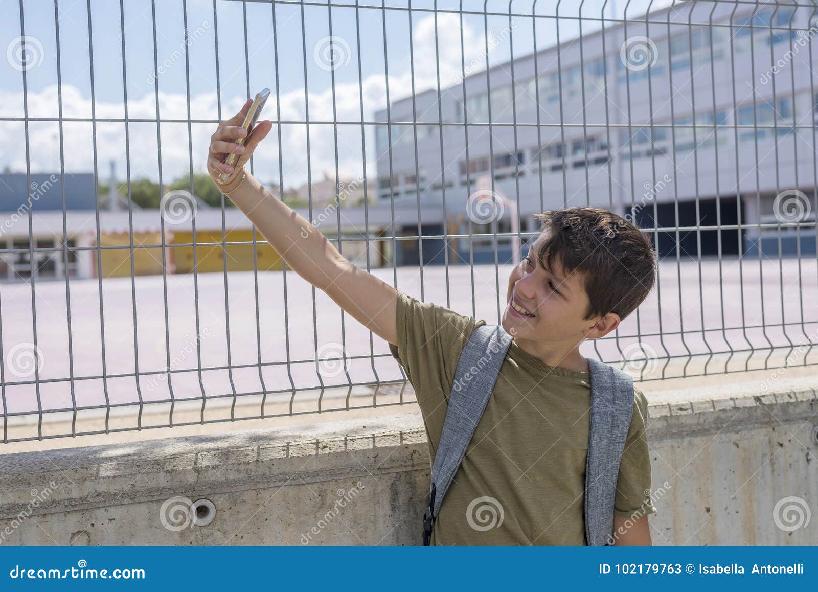 Student Resting Outside a School and Playing with a Mobile Phone Stock ...