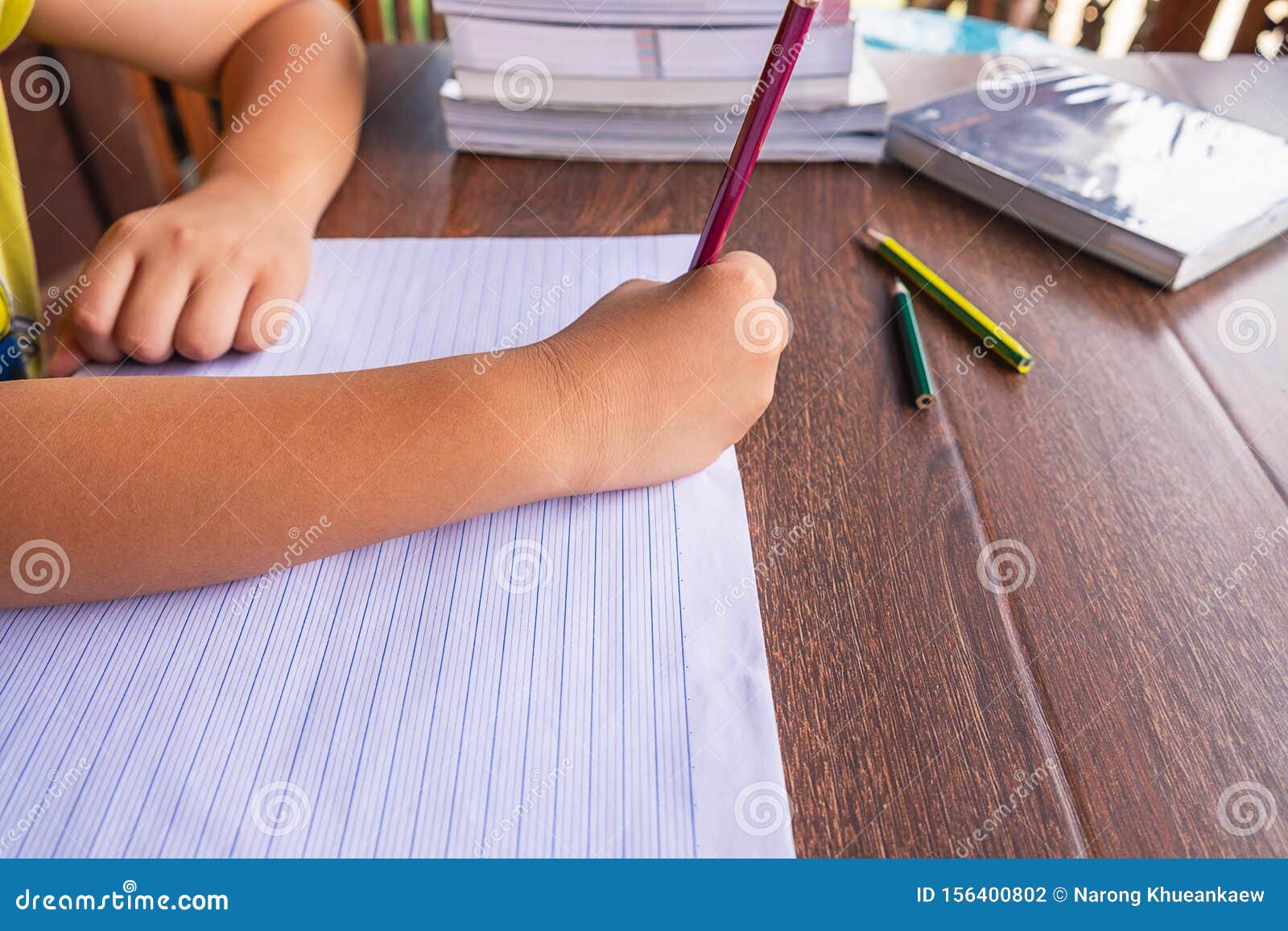 The Student`s Hand is Written on Paper on the School Table Stock Photo ...