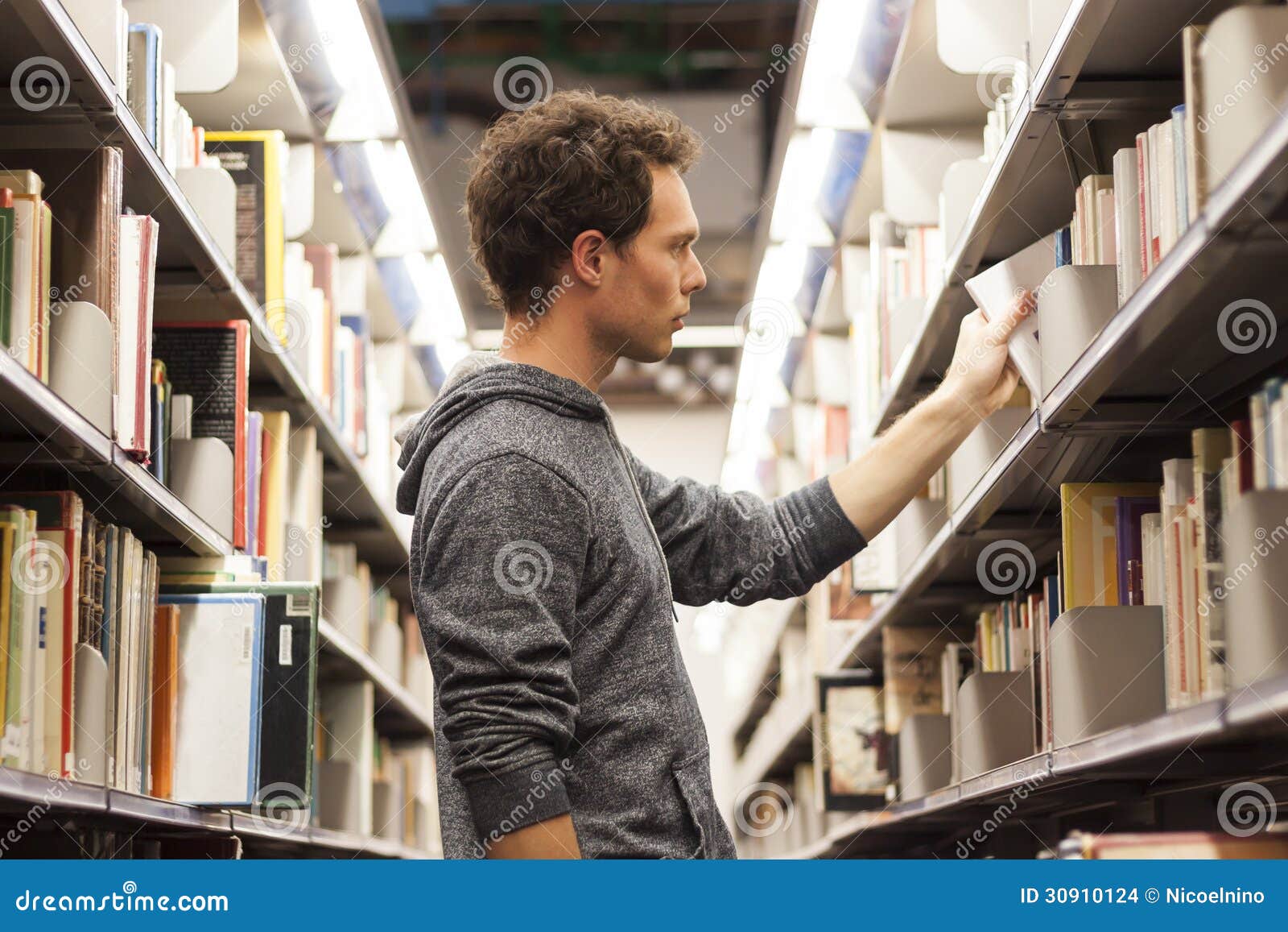 Student Selecting a Book in a Library Stock Photo - Image of shelf ...