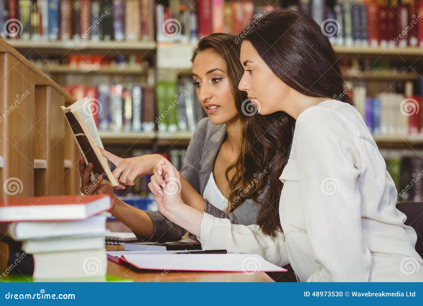 Student Showing Something To Her Classmate in the Book Stock Photo ...