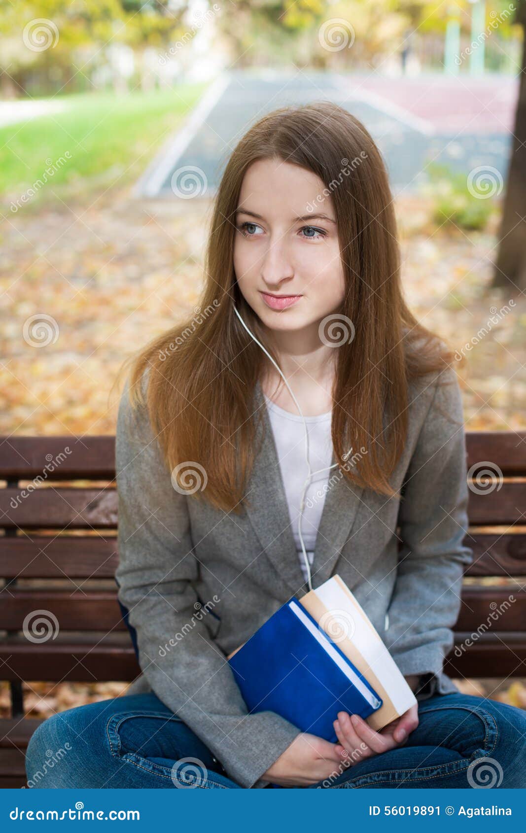 Student Sitting on Bench with Headphones and Book Stock Image - Image ...