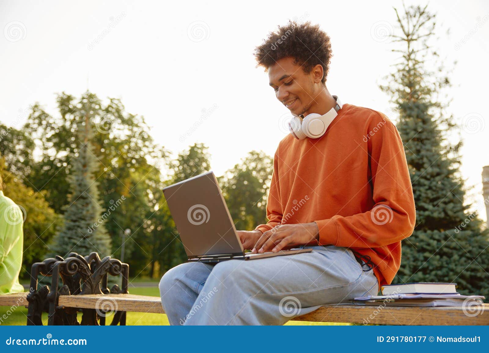 Student Sitting on Bench in University Park and Studying on Laptop ...