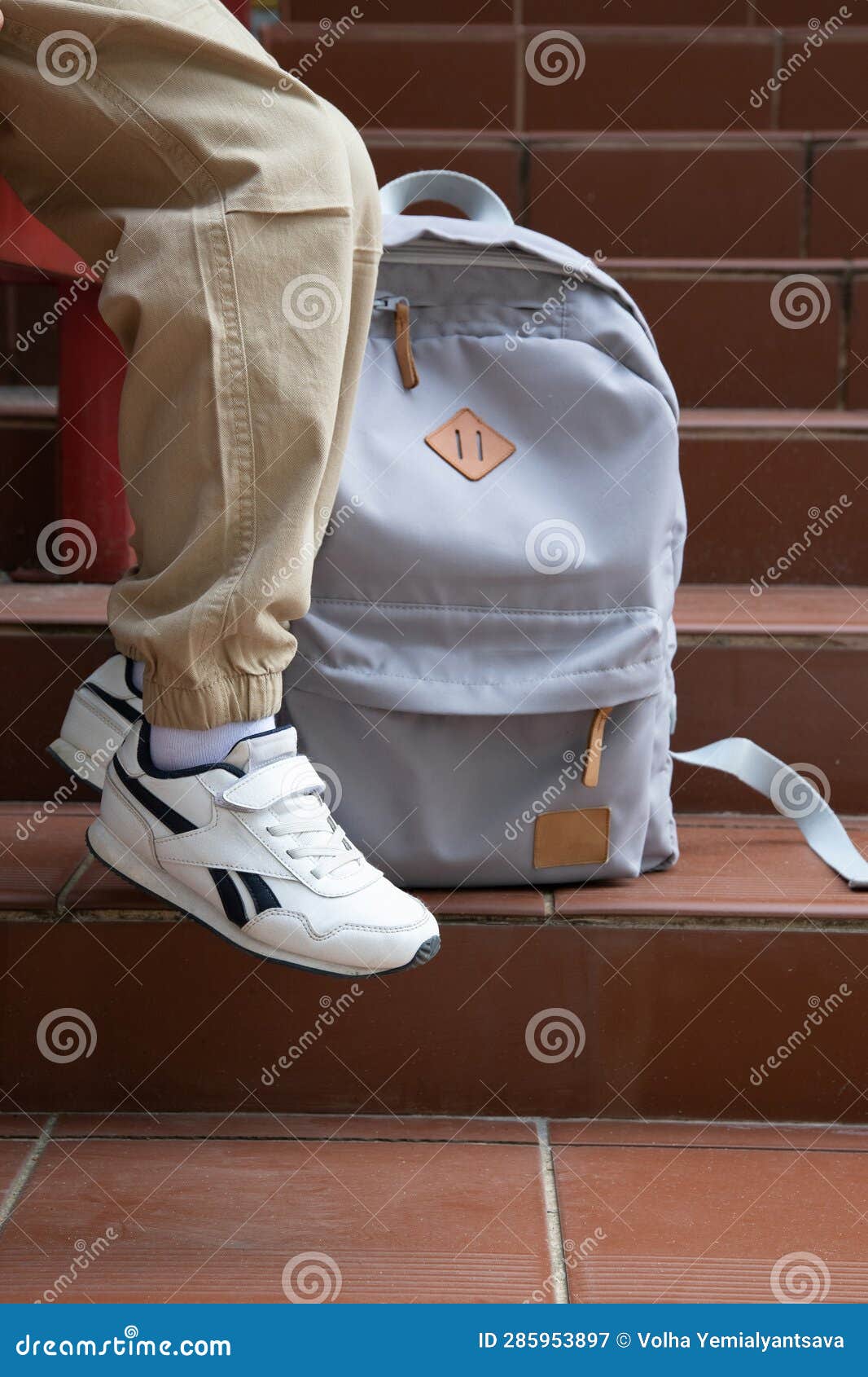 A Student is Sitting on the Steps Near the School. Backpack on the ...