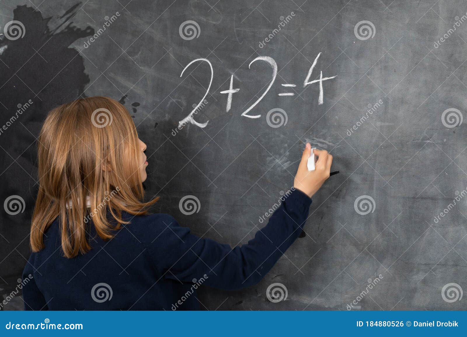 The Student Solves a Math Problem Standing at the Blackboard in Her ...