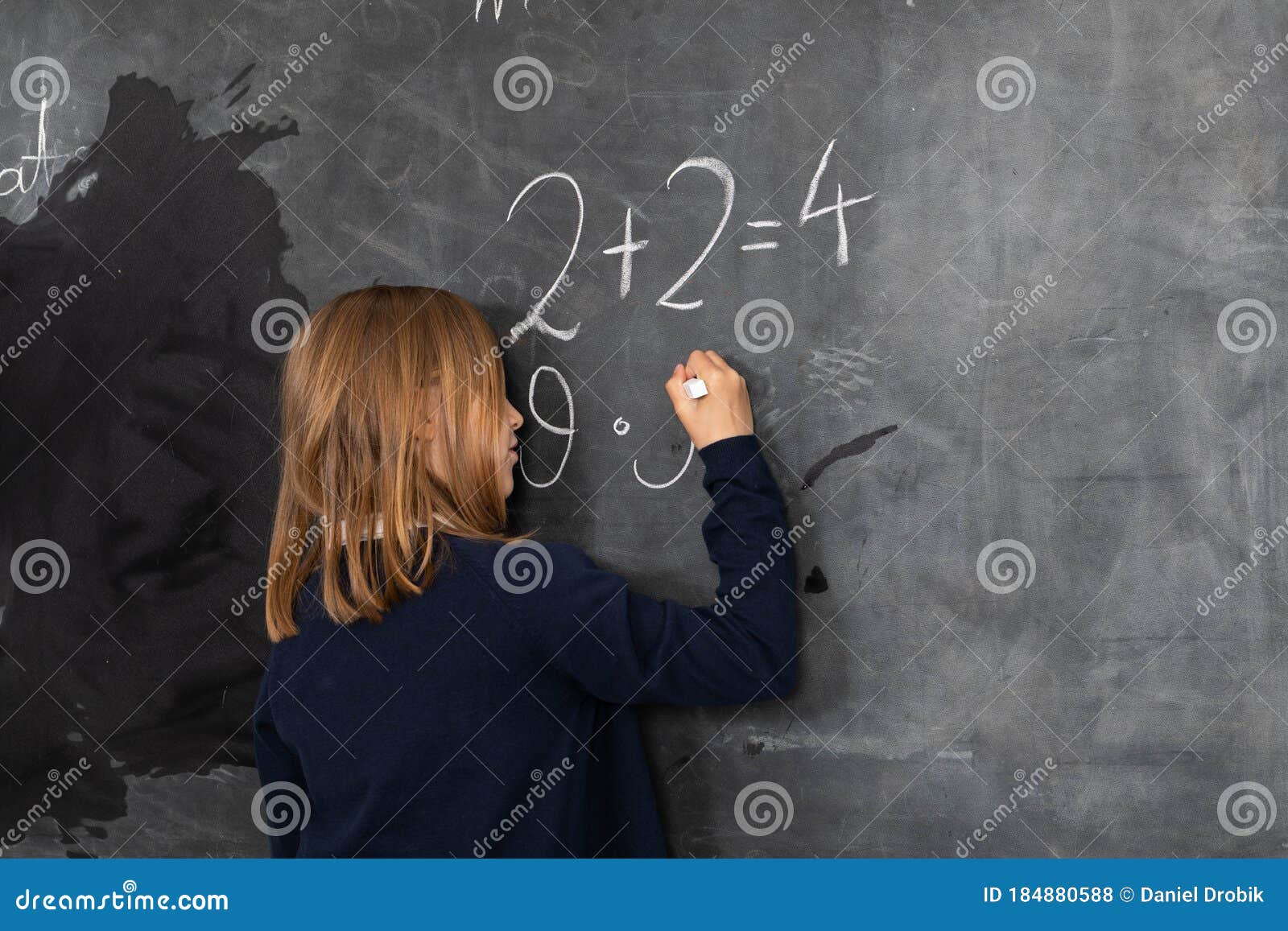 The Student Solves a Math Problem Standing at the Blackboard in Her ...