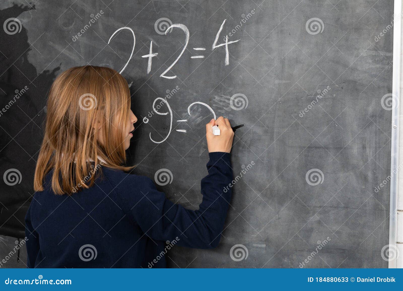 The Student Solves a Math Problem Standing at the Blackboard in Her ...