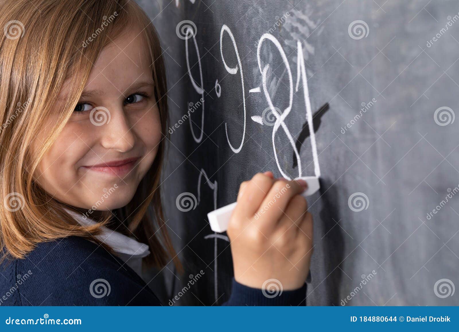 The Student Solves a Math Problem Standing at the Blackboard in Her ...