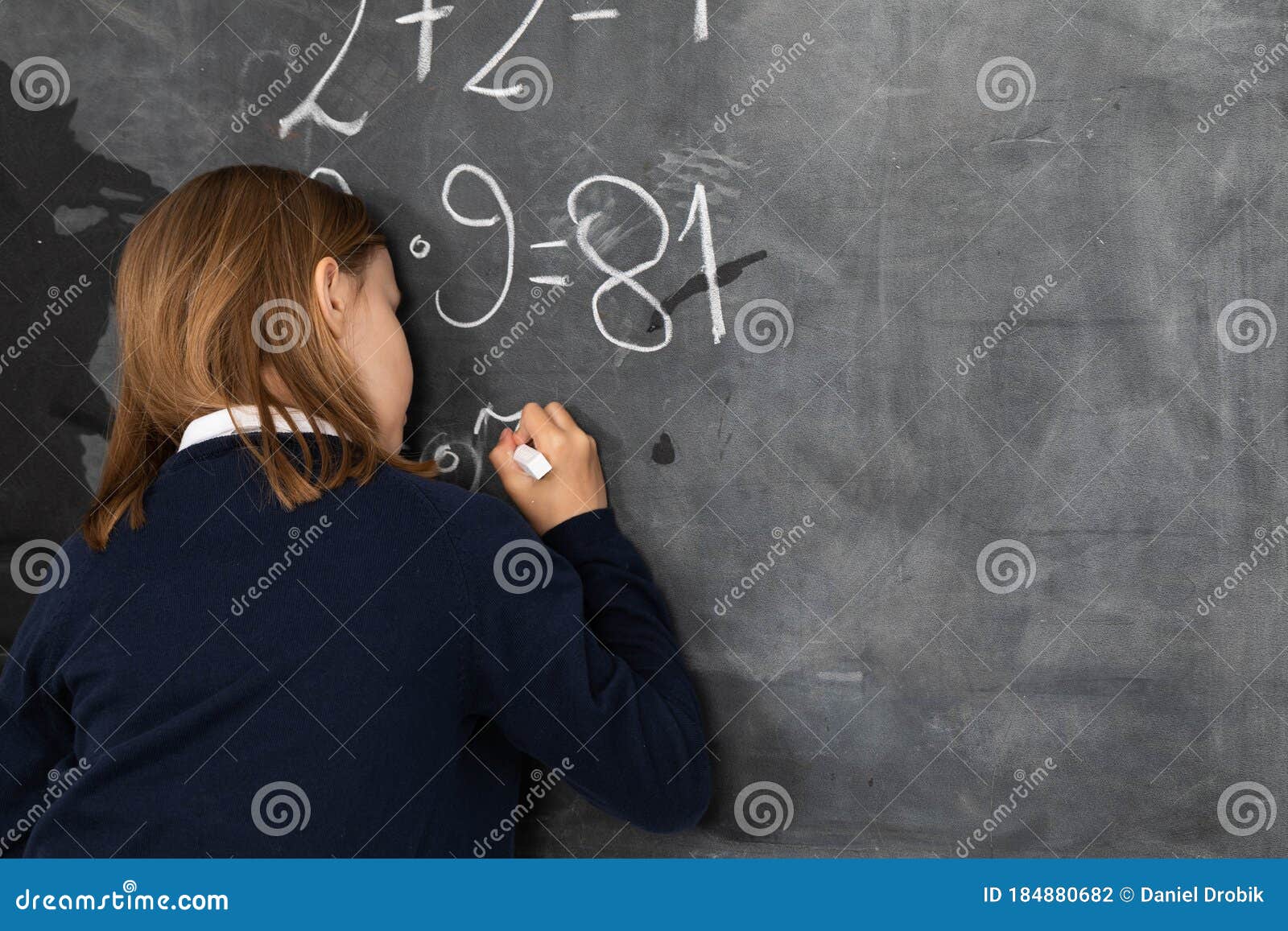 The Student Solves a Math Problem Standing at the Blackboard in Her ...