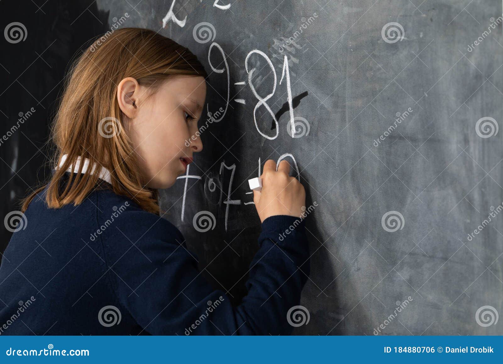 The Student Solves a Math Problem Standing at the Blackboard in Her ...