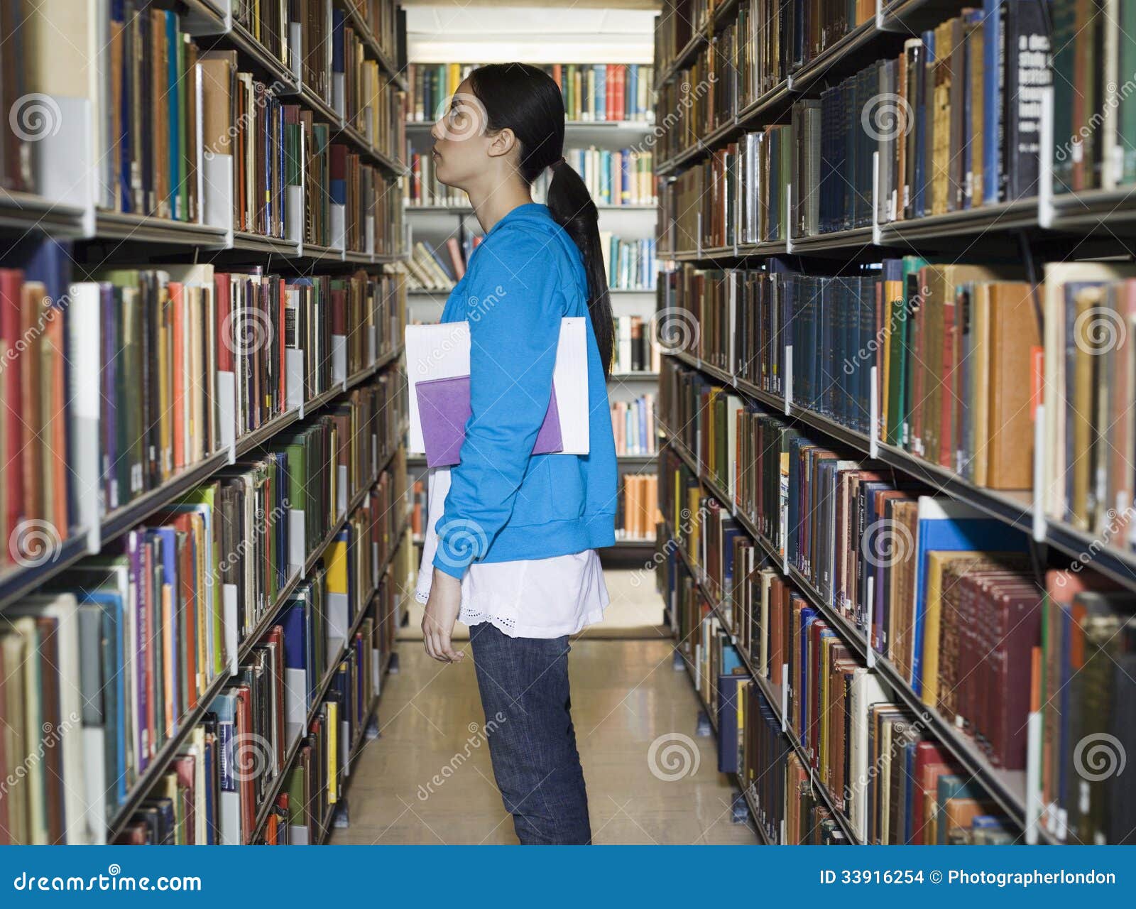 Student Standing by Bookshelf in Library Stock Photo - Image of ...