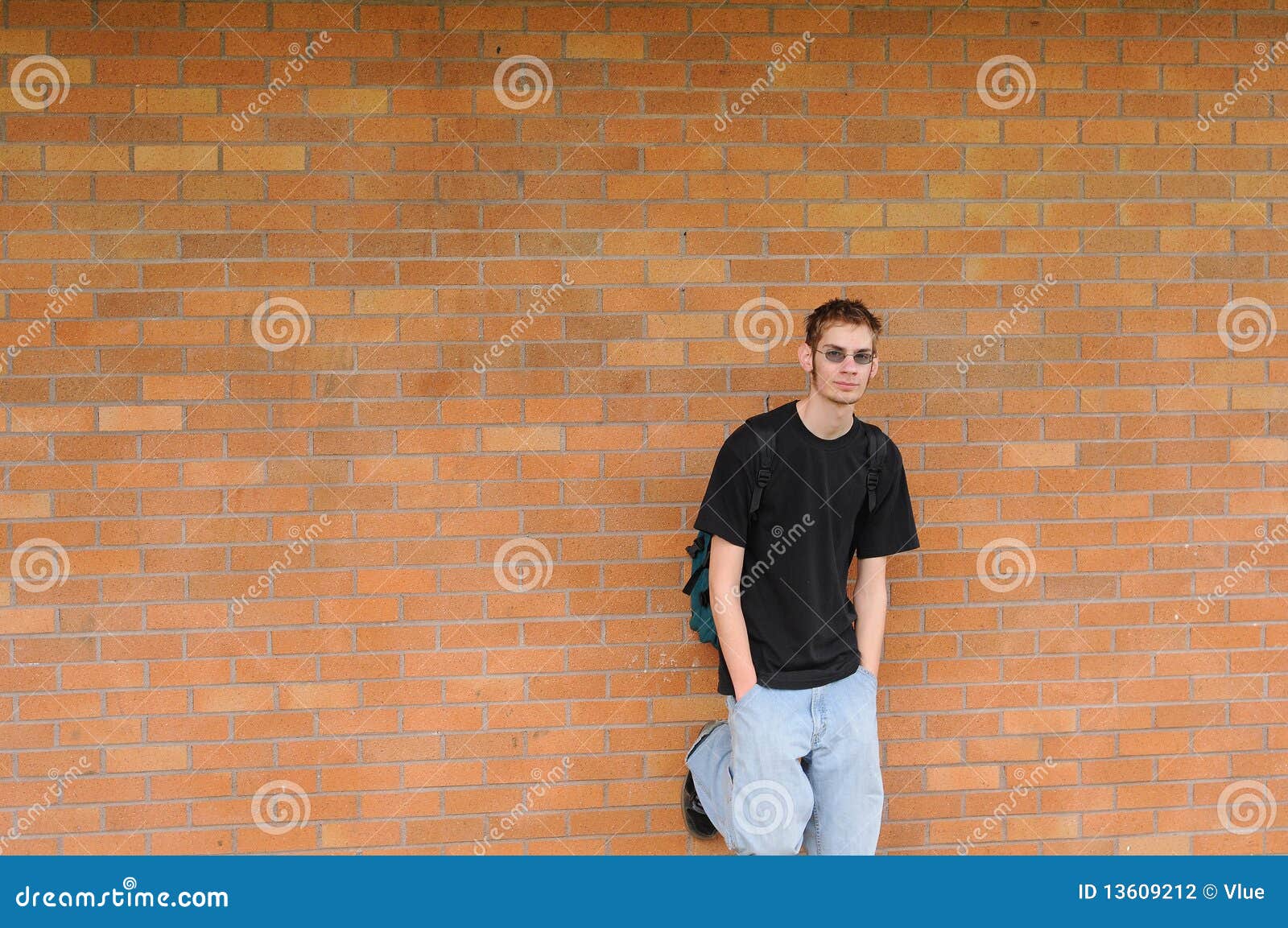 Student Standing in Front of Brick Wall Stock Photo - Image of adult ...