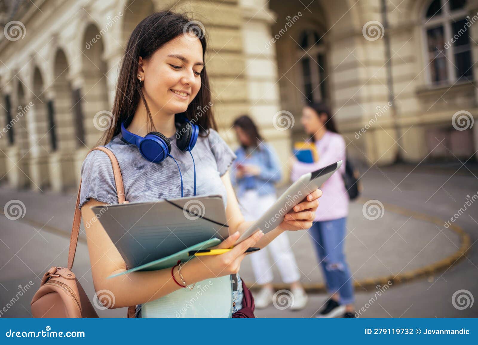 Student Standing with Her Note-book while Her Friends are Studying ...