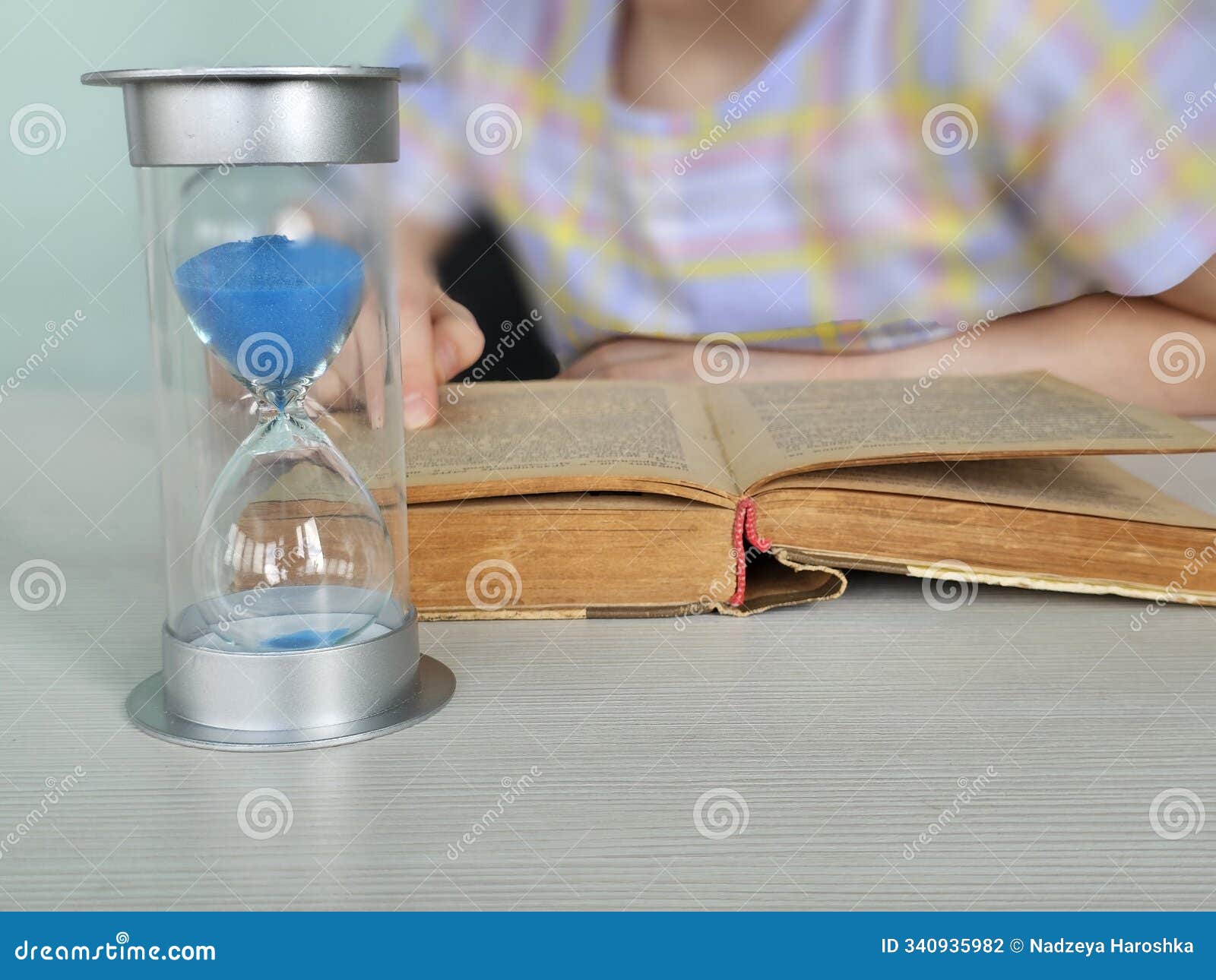 Student Studying with Hourglass and Open Book on Table Stock Photo ...