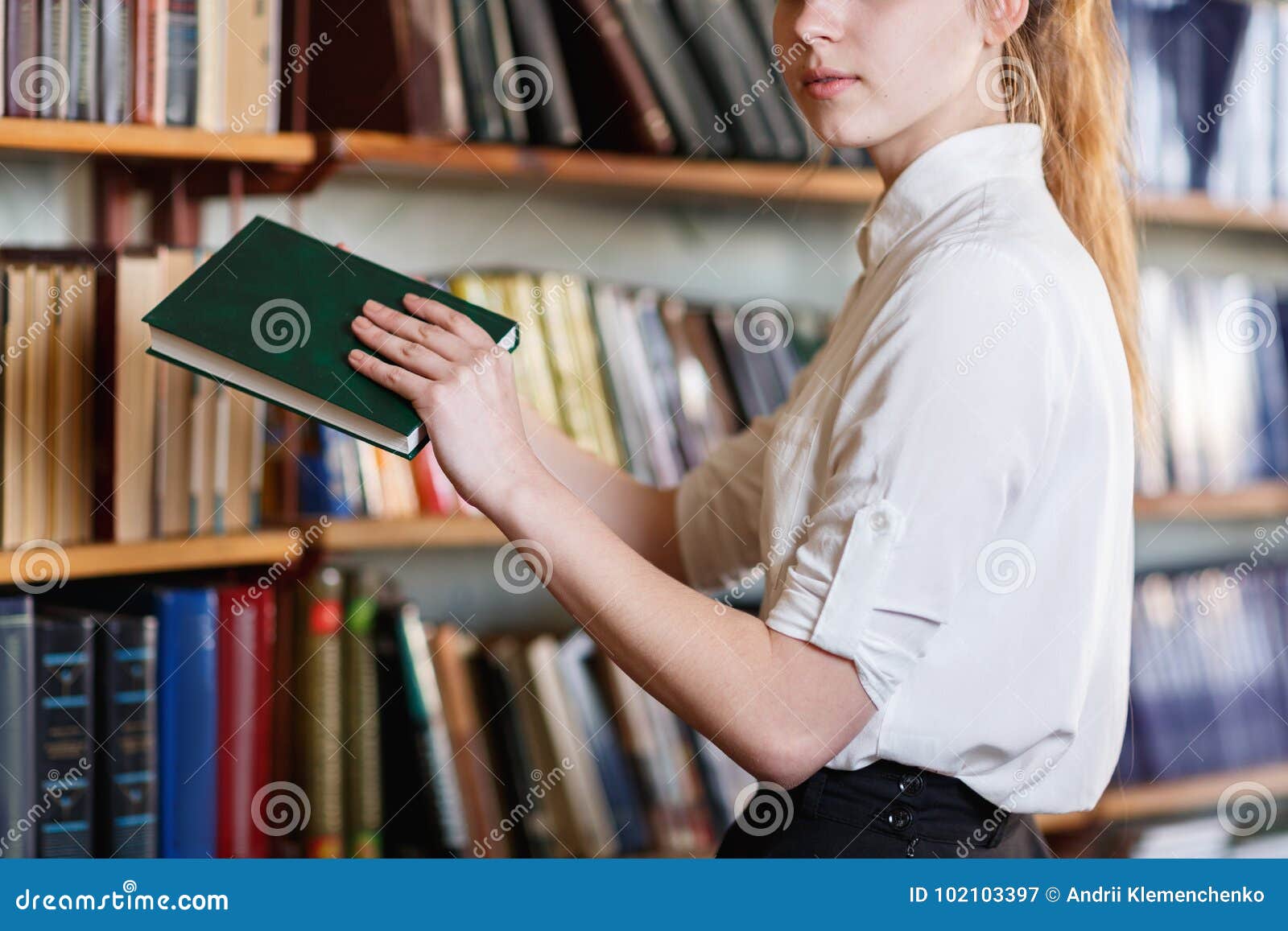 A Student Taking a Book from a Shelf in the Library. Stock Image ...