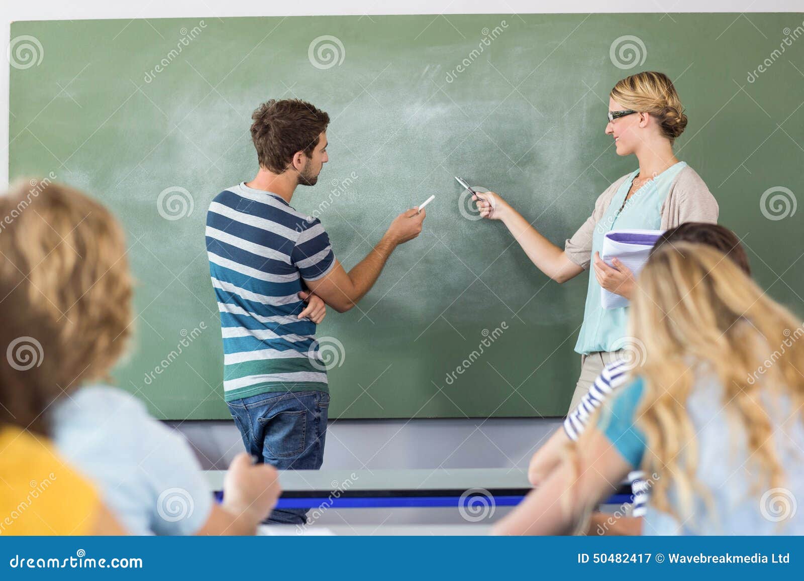 Student and Teacher Pointing at Blackboard Stock Image - Image of ...