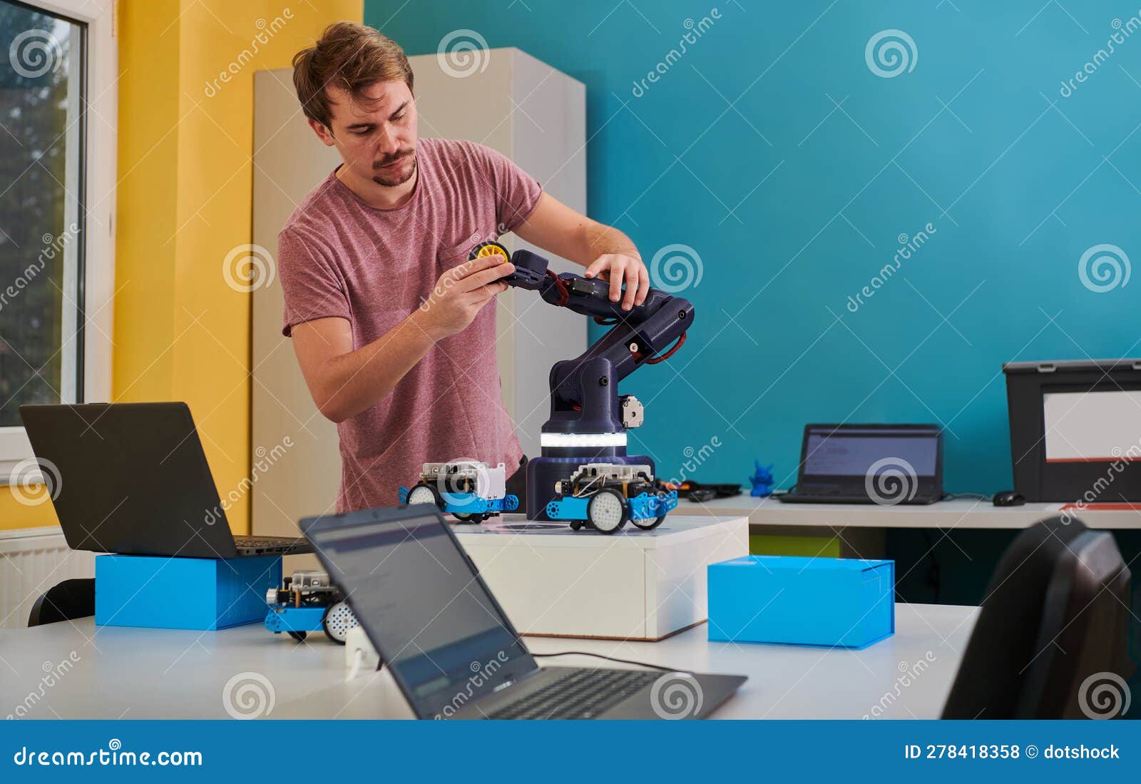A Student Testing His New Invention of a Robotic Arm in the Laboratory ...