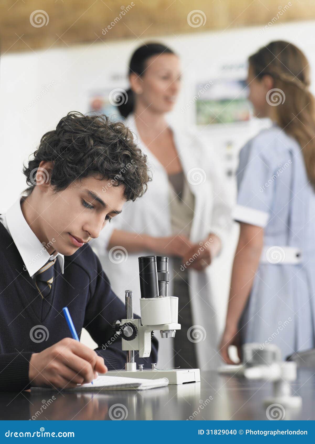 Student Using Microscope and Taking Notes in Laboratory Stock Photo ...