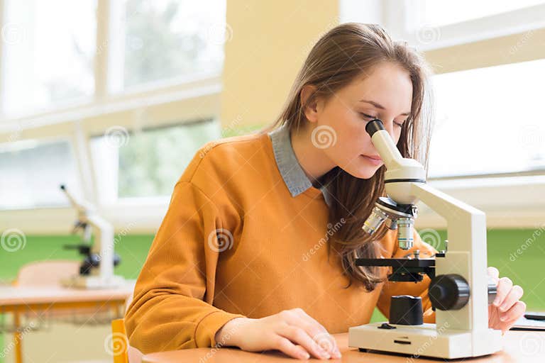 Student Using Microscope To Examine Samples in Biology Class. Stock ...
