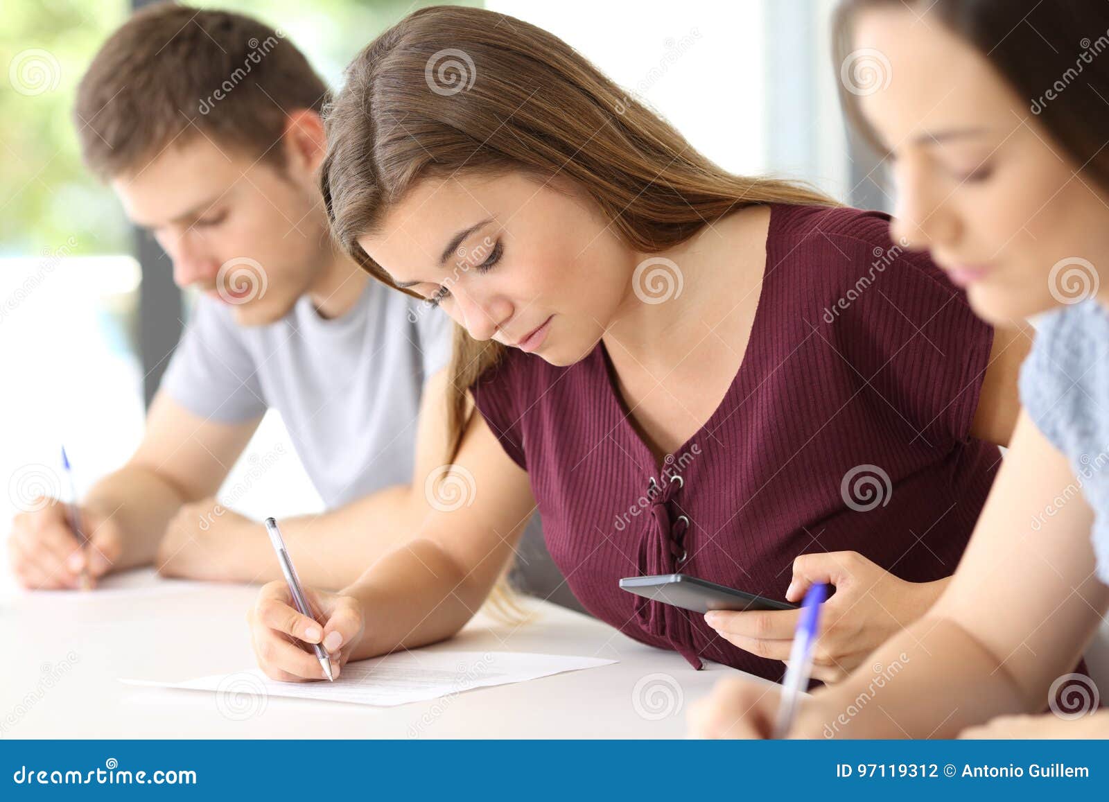 Student Using a Smart Phone during an Exam Stock Photo - Image of girl ...