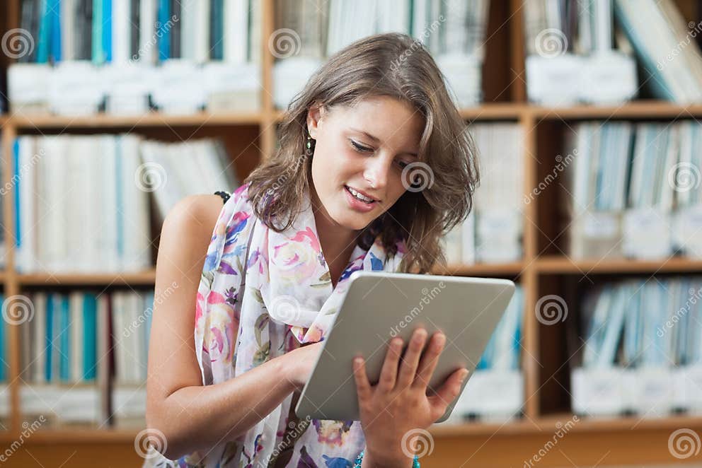 Student Using Tablet PC Against Bookshelf in Library Stock Image ...