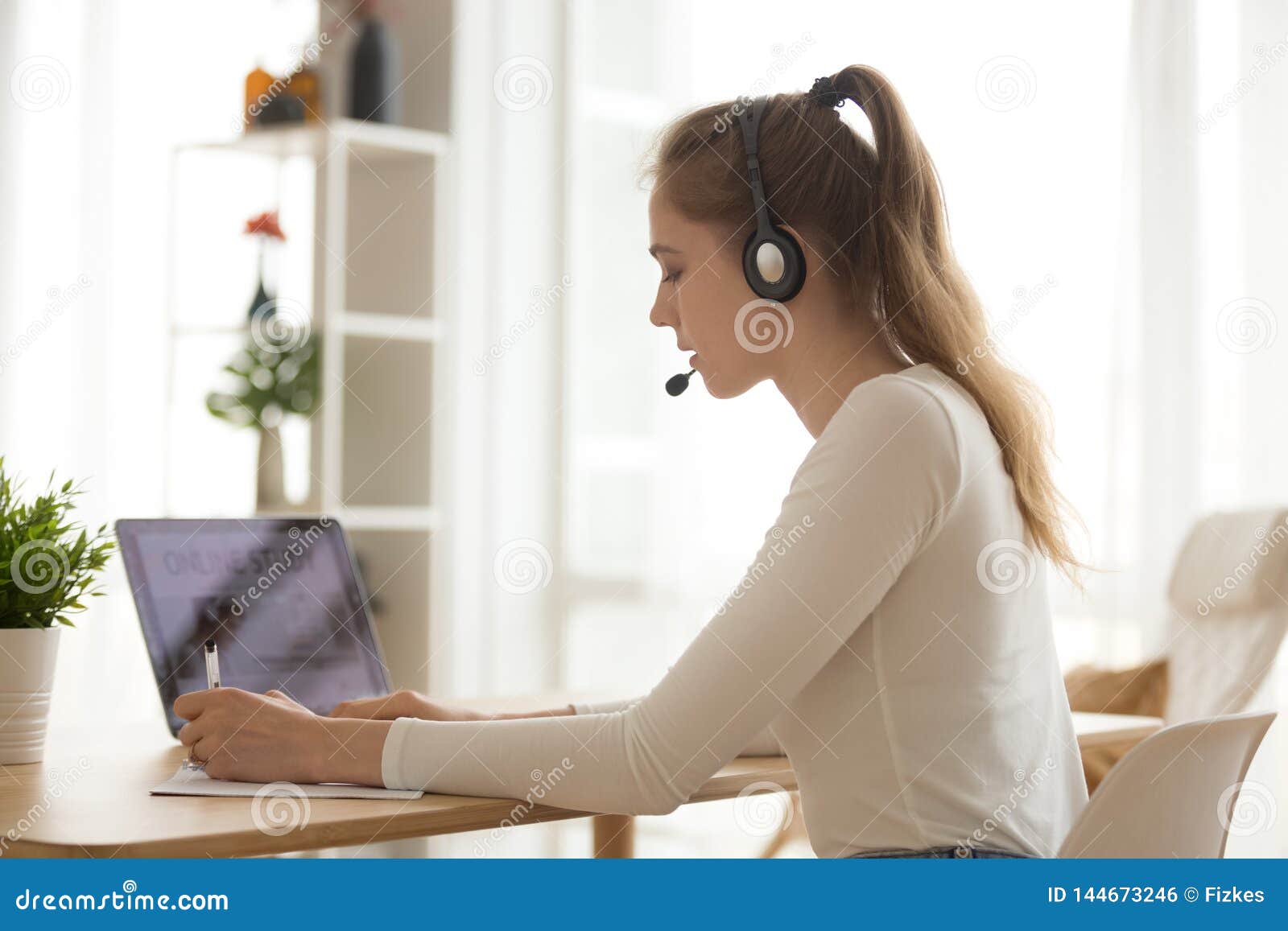 Student Woman in Headset Writing Notes, Using Laptop at Workplace Stock ...
