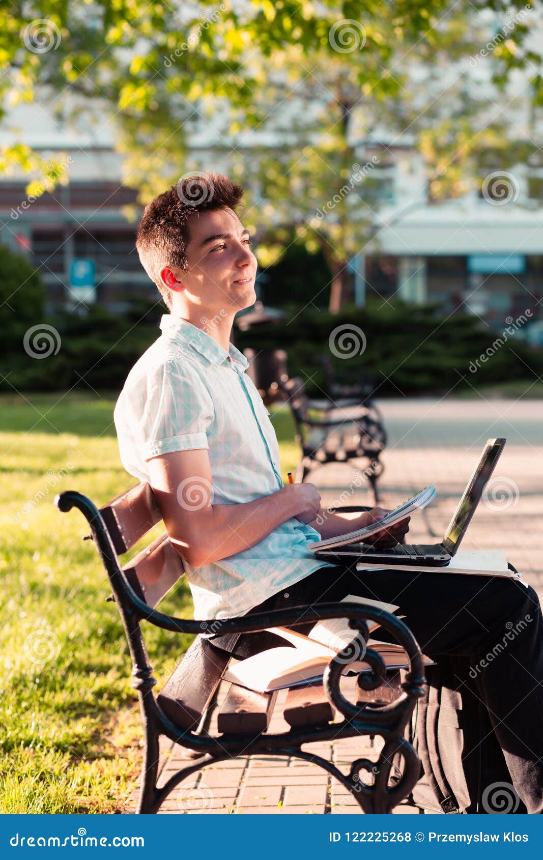 Student Working on Laptop Sitting on a Bench in the Park Stock Photo ...