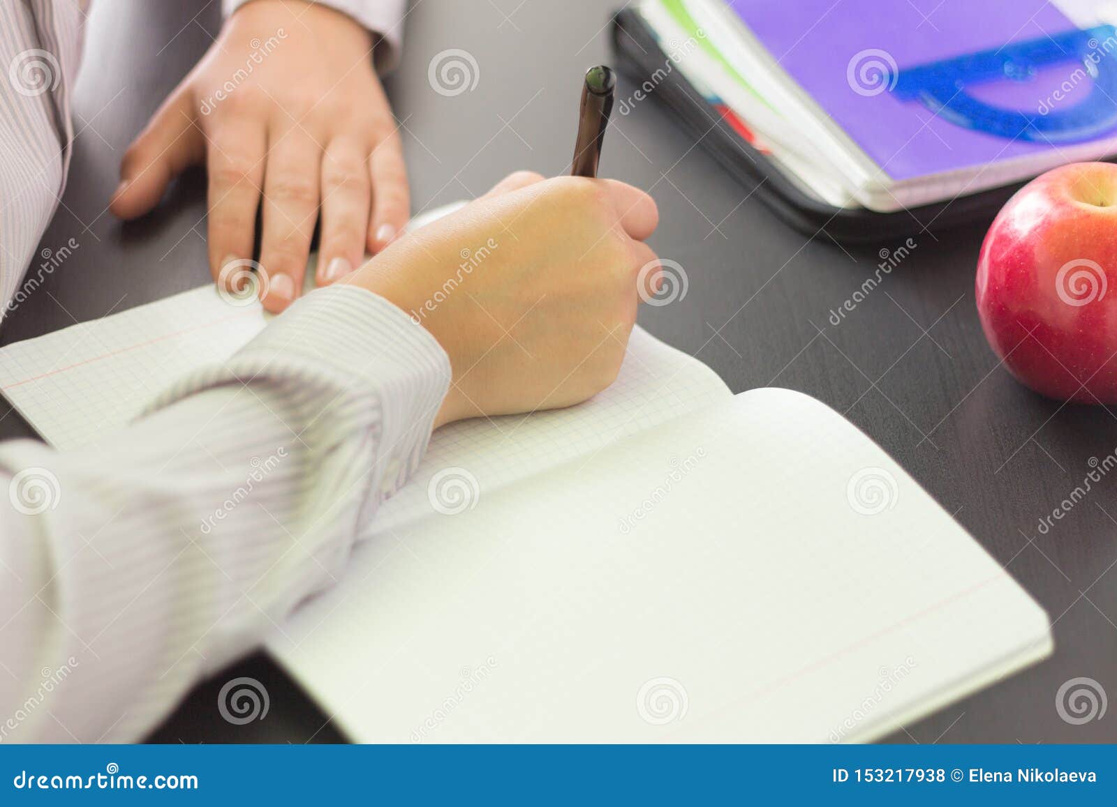 The Student Writes in a Notebook, Doing Homework at His Desk Stock ...